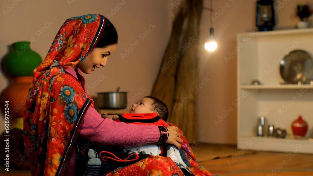 A cheerful village lady with her newborn baby - village home caring ...
