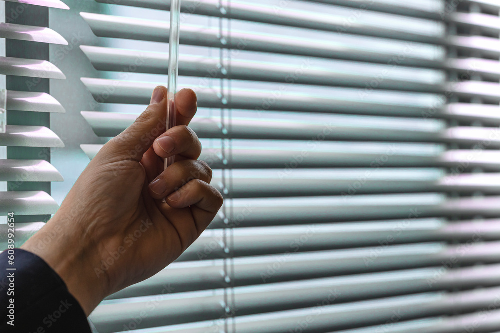Office blinds. close up view of man opening modern blinds to control ...