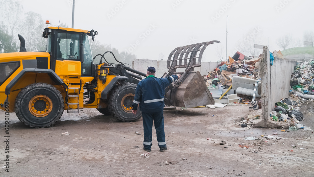 Yellow skid steer loader moving wooden waste material, shaking out a ...
