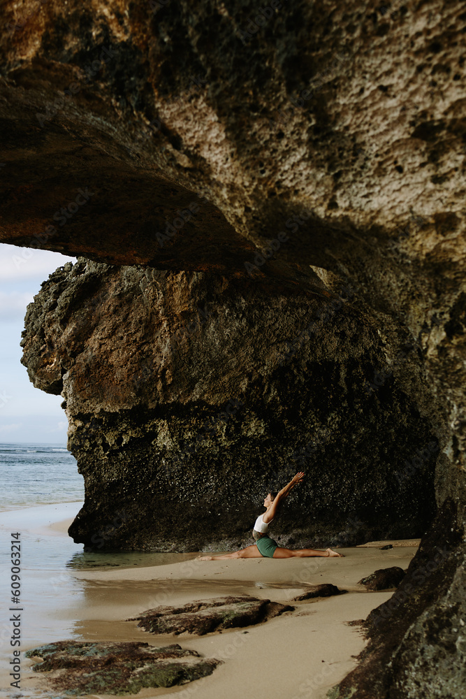 Flexible fit girl exercising by the ocean, fit woman doing leg stretch ...