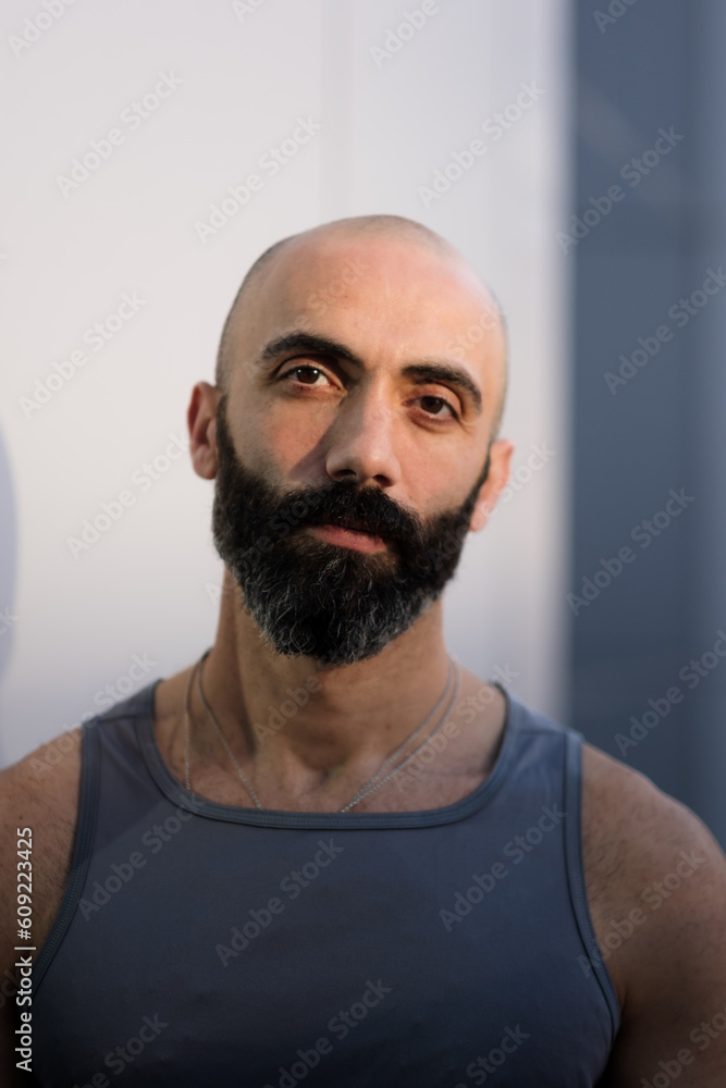 With his head slightly tilted, a man poses for a portrait and catches ...