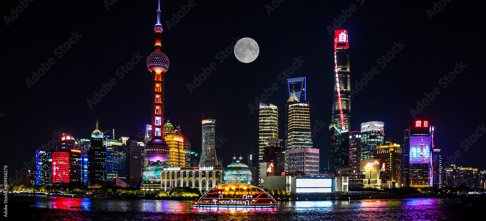 Night view of Shanghai under full moon with tour boat on Huangpu River ...