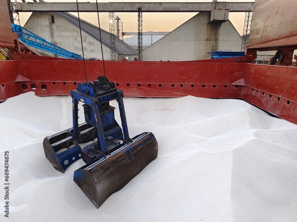 A grab is grabbing cargo in the hold of cargo ship or a bulk carrier ...