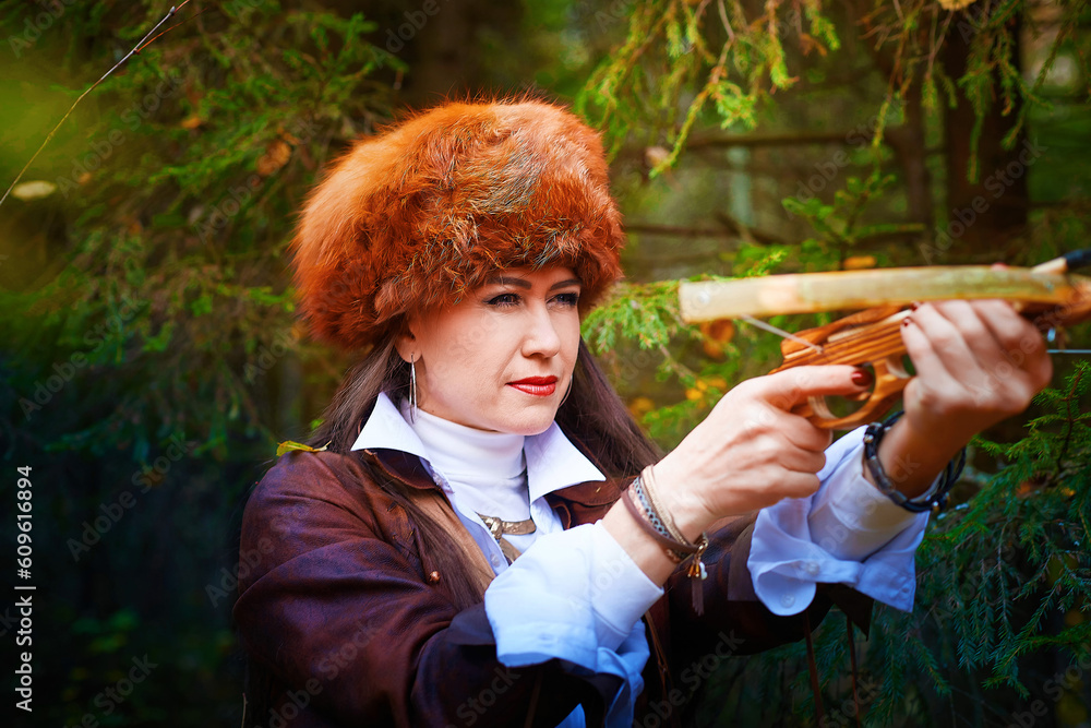 Girl in a leather jacket, a big red fox fur hat and with a crossbow in ...