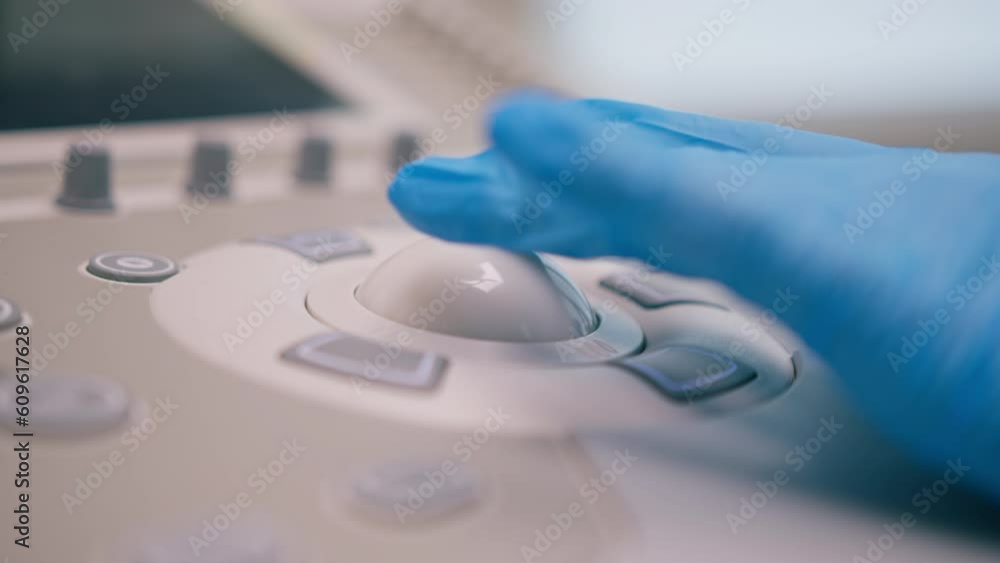 A gynecologist uses a transvaginal ultrasound device presses buttons ...