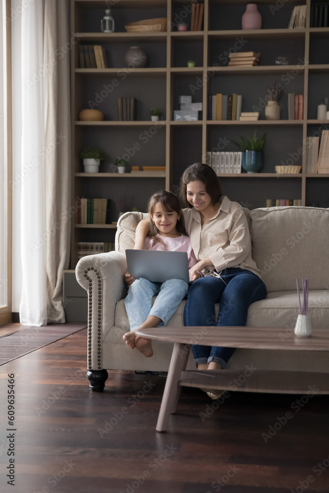 Happy mom teaching kid to use learning application, software on laptop ...
