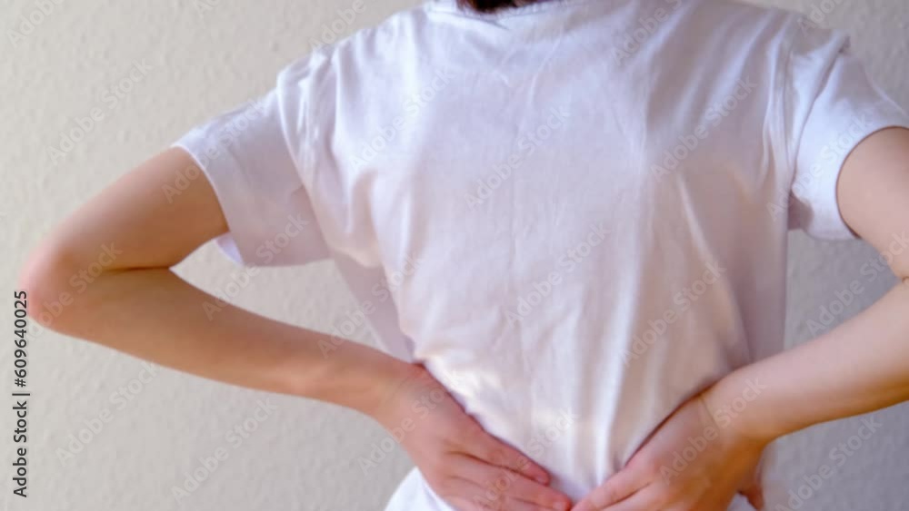 back of boy, child 8-10 years old in white t-shirt grabbed sore spot ...