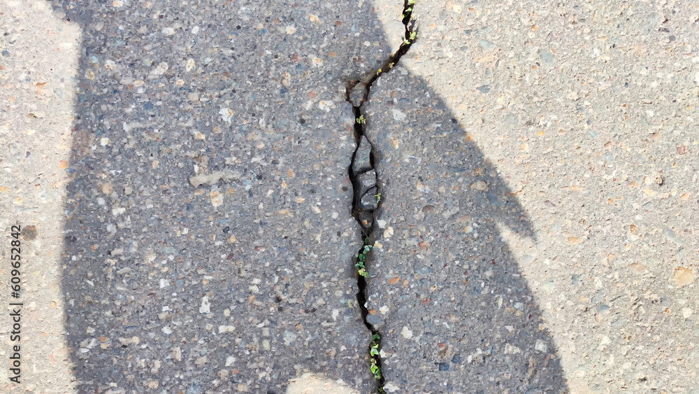 Abstract grey background and asphalt texture with a black curved crack ...