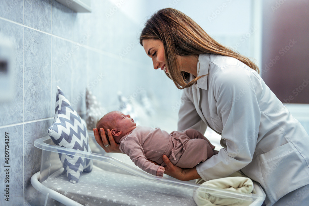Pediatrician taking care of newborn baby at hospital ward. A female ...