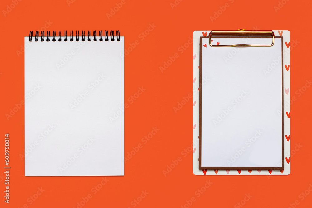 Two notepads with white blank sheets on an orange background. Two ...
