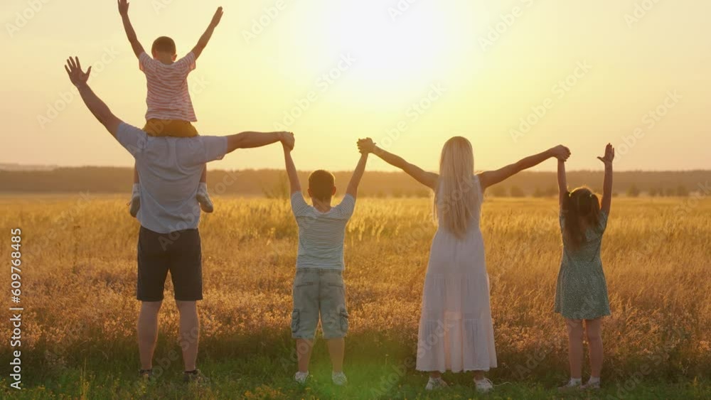 Happy family raise their hands outdoor at sunset. Teamwork of group of ...