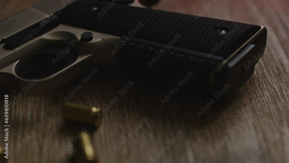 Static view of pistol grip and spent bullet casings on crime scene lit ...