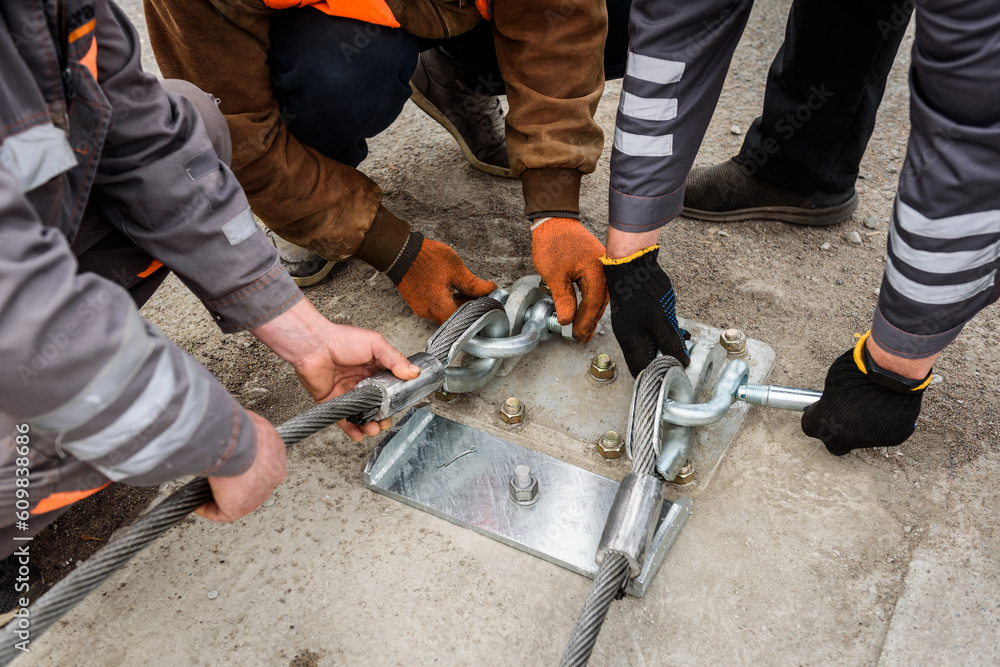 Cable tensioning. Installation of support in crash barriers on highway ...
