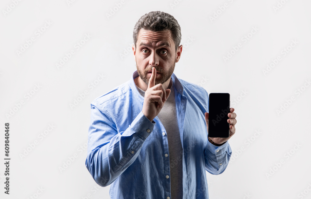 secret man showing phone app isolated on studio background. man showing ...