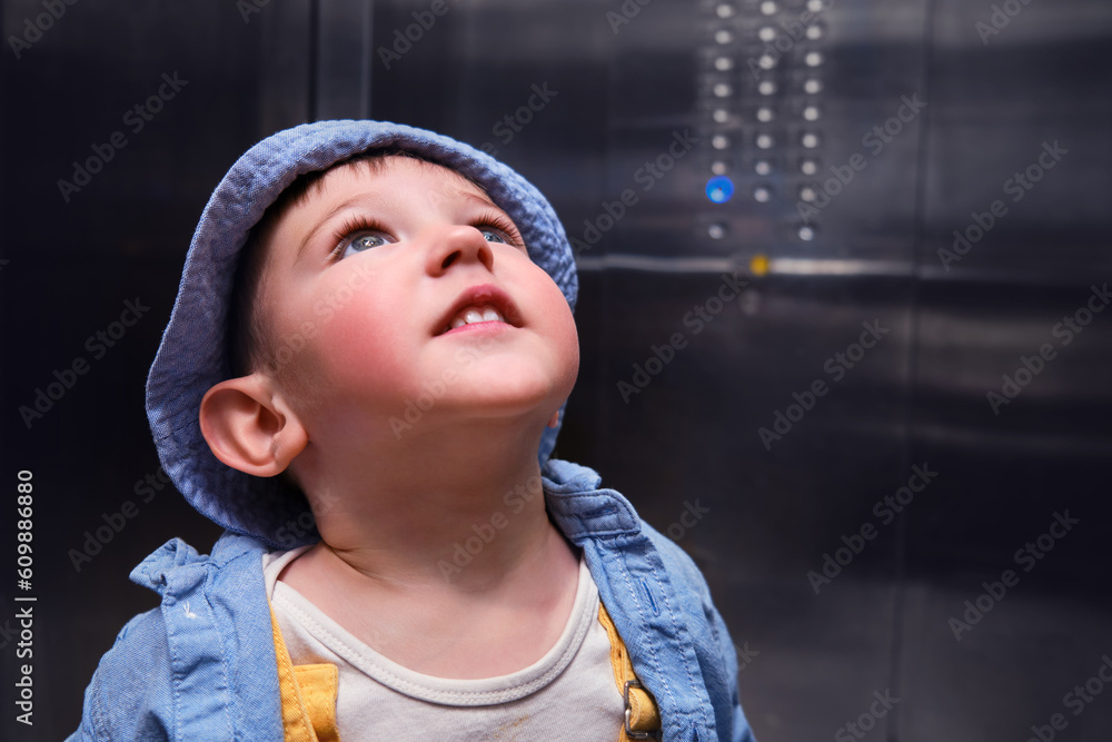 Happy baby rides in the elevator of an apartment building with buttons ...