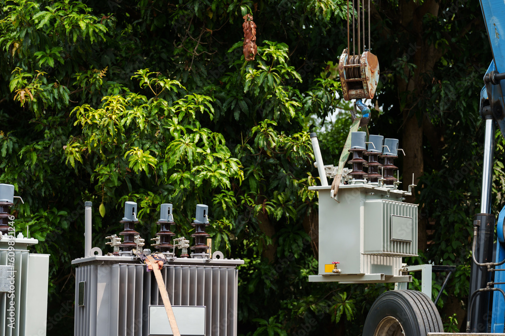 Crane hook lifts up distribution transformer Stock Photo | Adobe Stock