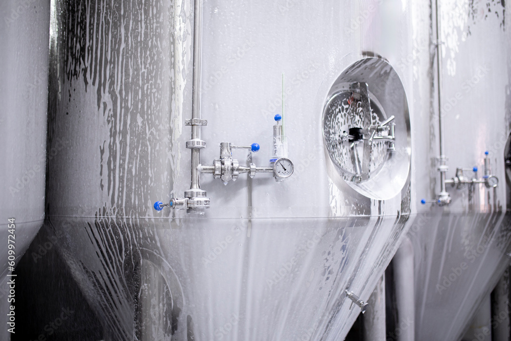 washing large metal tanks in warehouse on the drink production factory ...