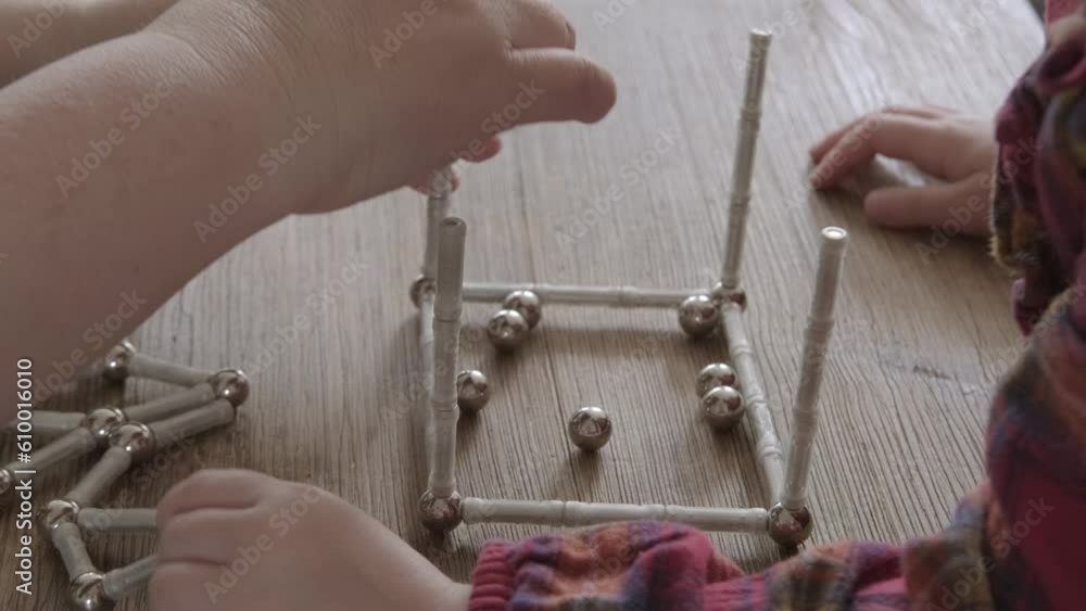 mother and child together assemble structures from magnetic constructor ...