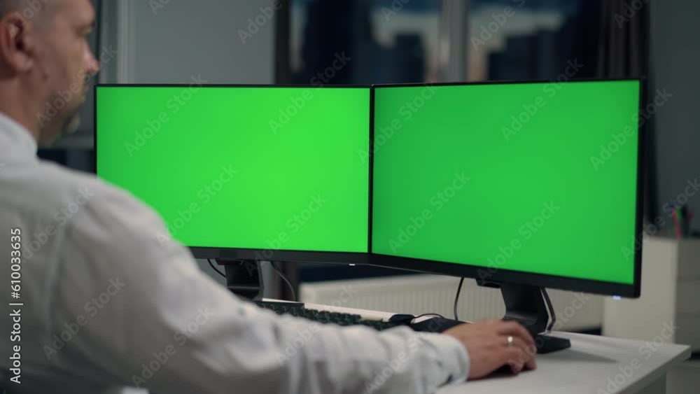 Man Uses Desktop Computer With Two Green Screen Mock Ups Working at ...