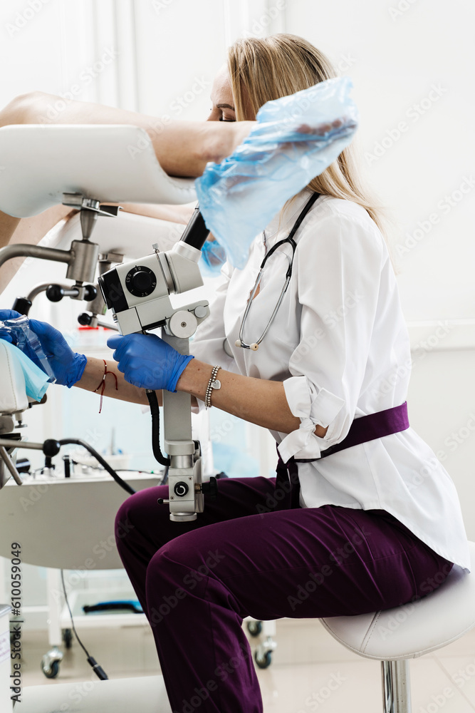 Gynecologist does colposcopy procedure to closely examine cervix, vagina and vulva of girl in ...