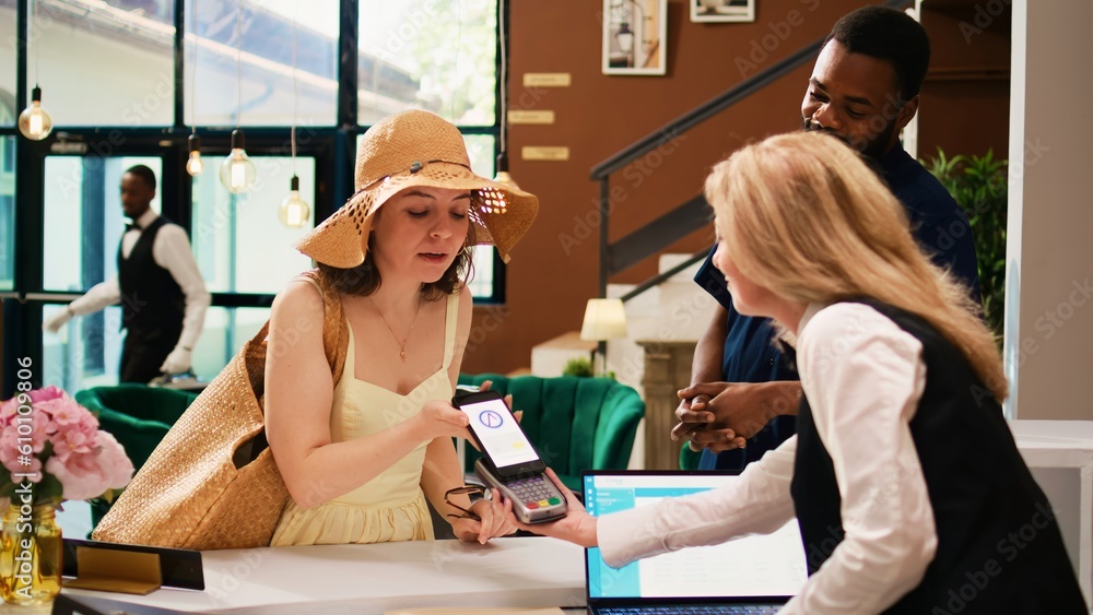 Tourists using nfc payment at reception, paying for room at exotic ...