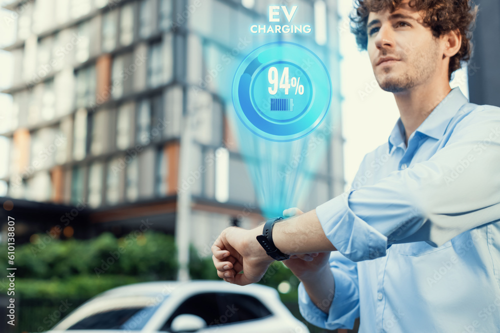 Progressive businessman check wearable hologram watch on electric car ...