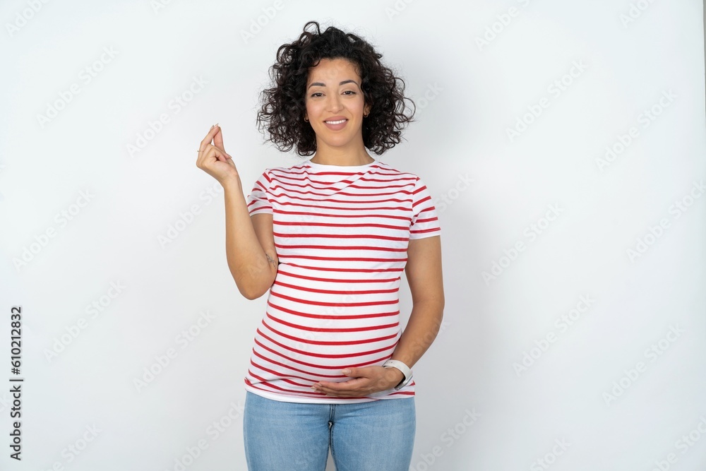 young pregnant woman wearing striped t-shirt over white background ...