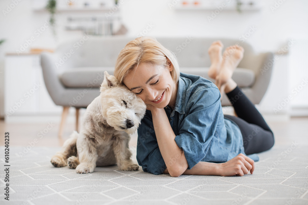 Foto de Kind female person and faithful small terrier snuggling to each ...