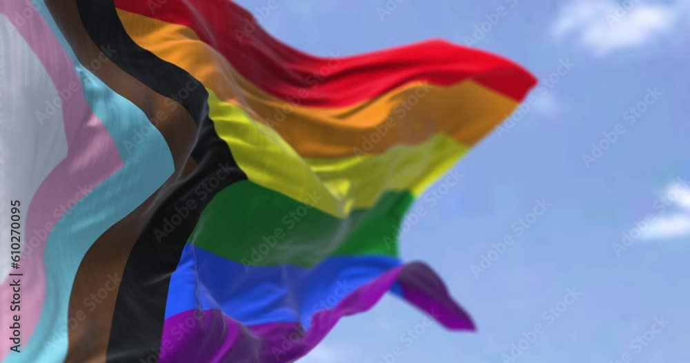 Seamless loop in slow motion of Progress Pride flag waving on a clear ...