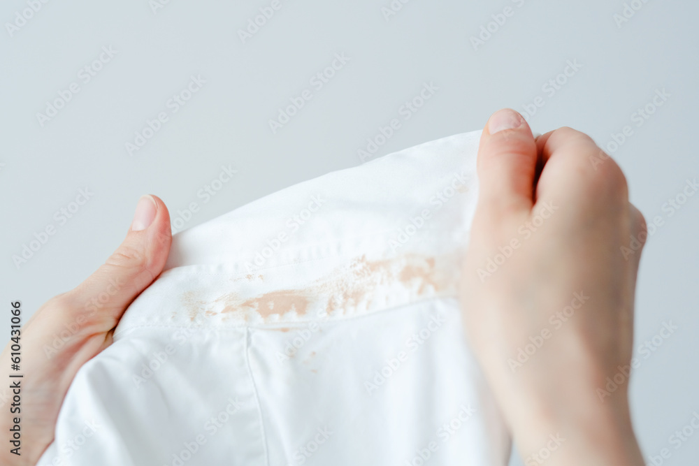 Hand showing dirty tea or coffee stain on white shirt. Visual ...