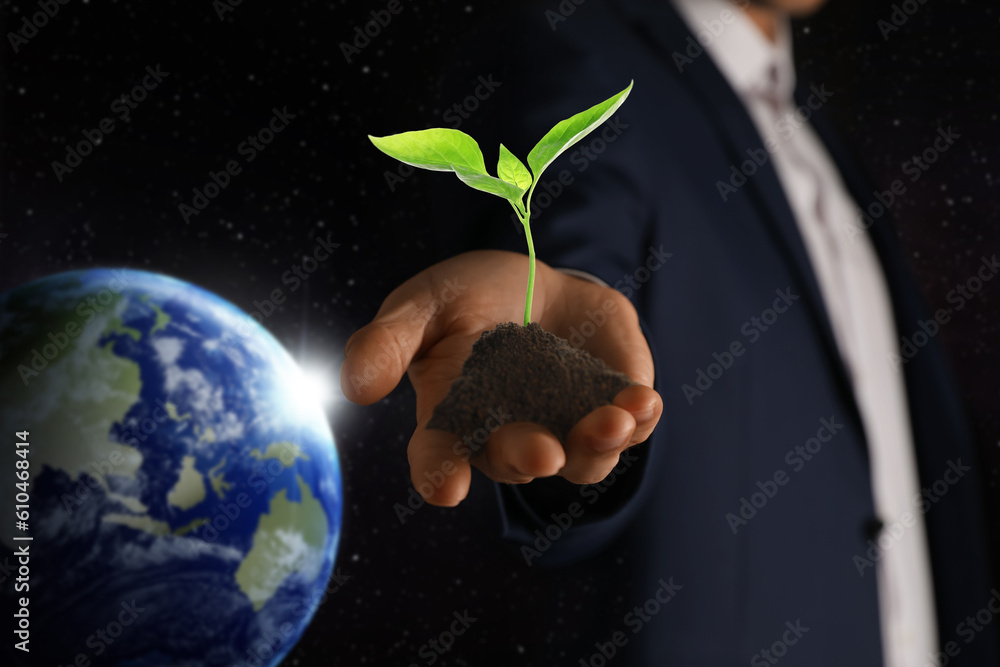 Make Earth green. Man holding soil with seedling, closeup. Black ...