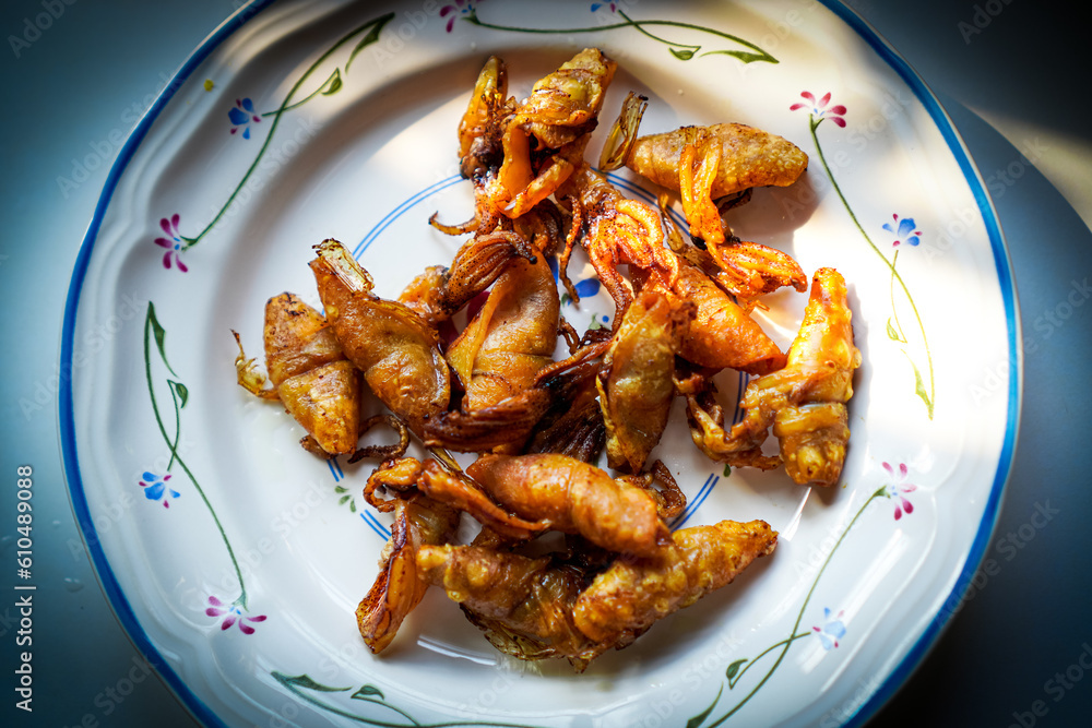 A top-view closeup shows a group of small squids being deep-fried and ...