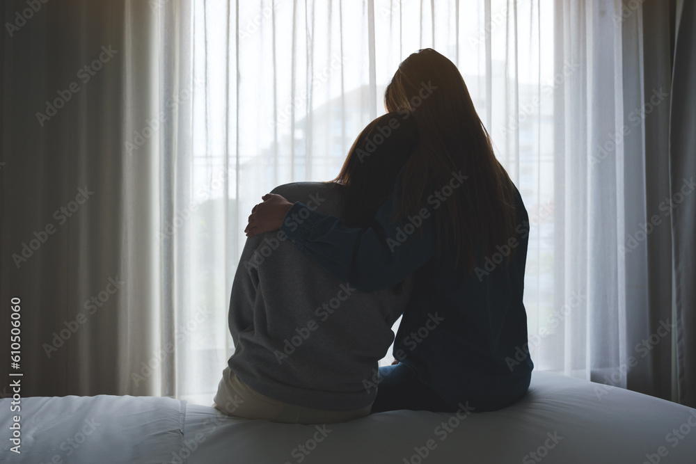 Silhouette image of a woman hugging her friend to comforting and giving ...