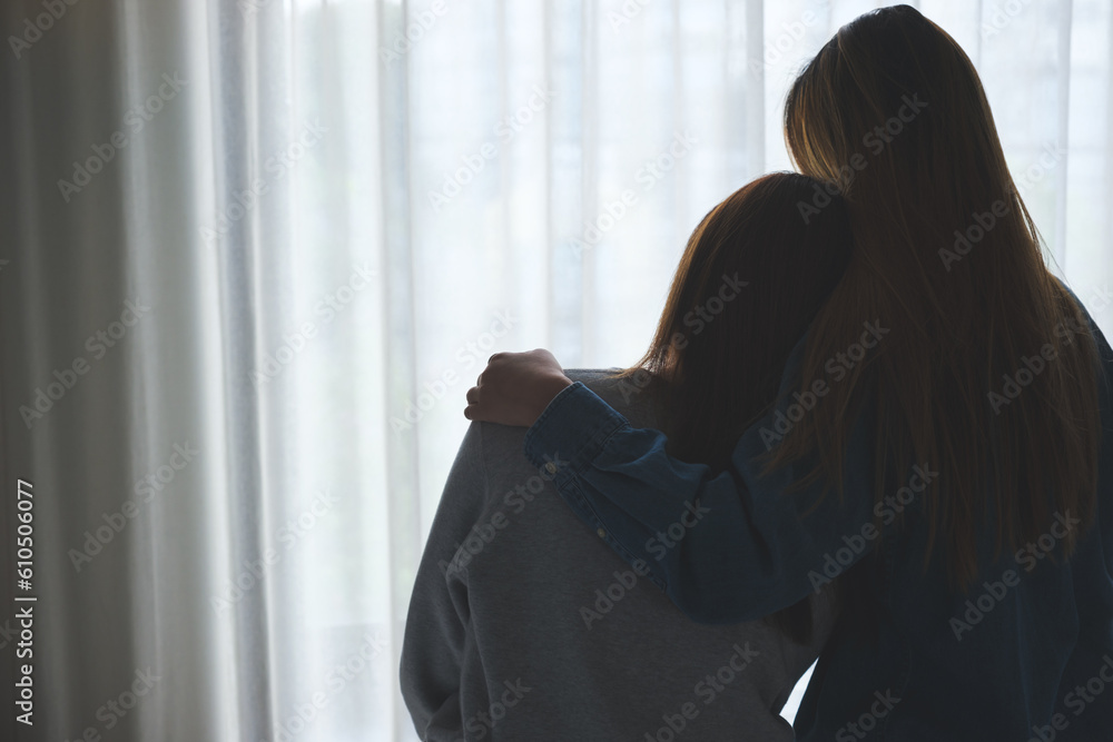 Silhouette image of a woman hugging her friend to comforting and giving ...