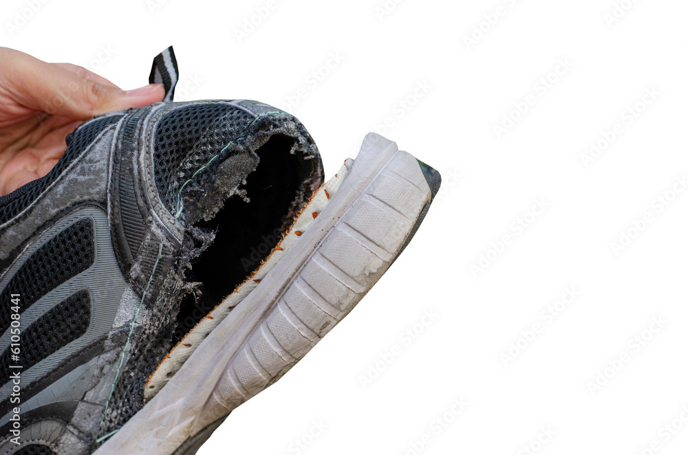 Hand holding an old, torn black shoe behind the heel of the shoe on ...