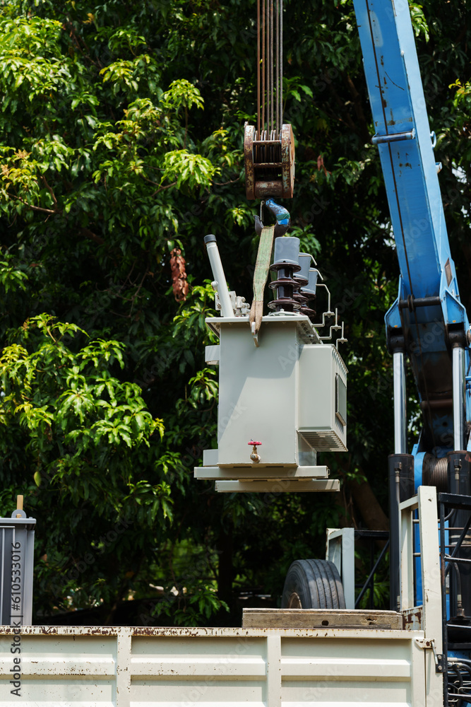 Crane hook lifts up distribution transformer Stock Photo | Adobe Stock