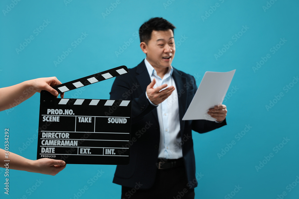 Happy asian actor performing role while second assistant camera holding ...