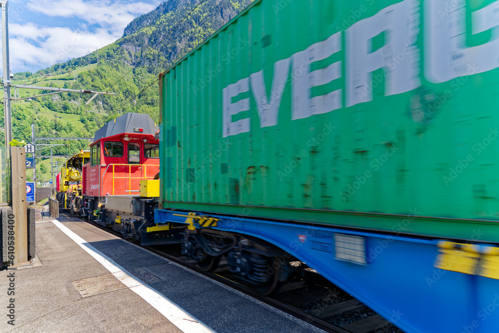 Foto de Freight train with container and construction train passing ...