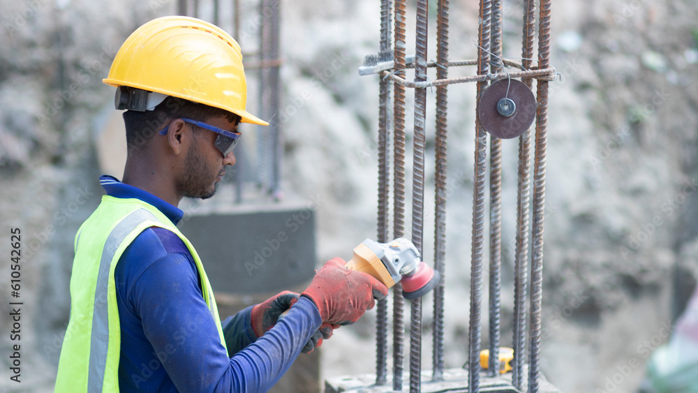 Worker tied steel in the site. The worker works with an angle grinder ...
