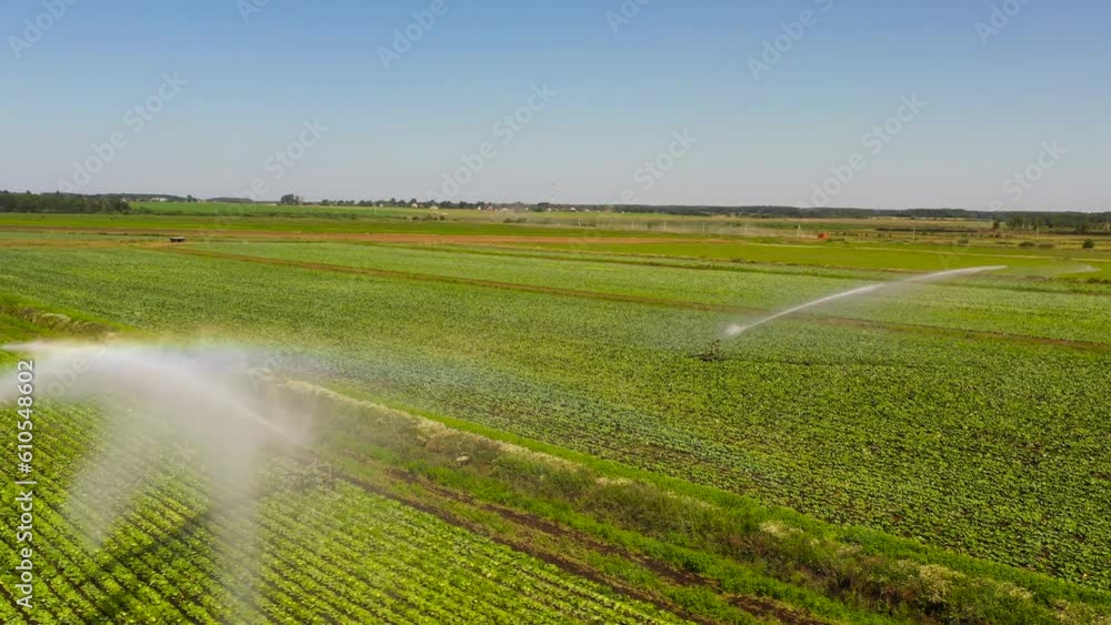 Irrigation of farmland with a tractor irrigation system from above. An ...
