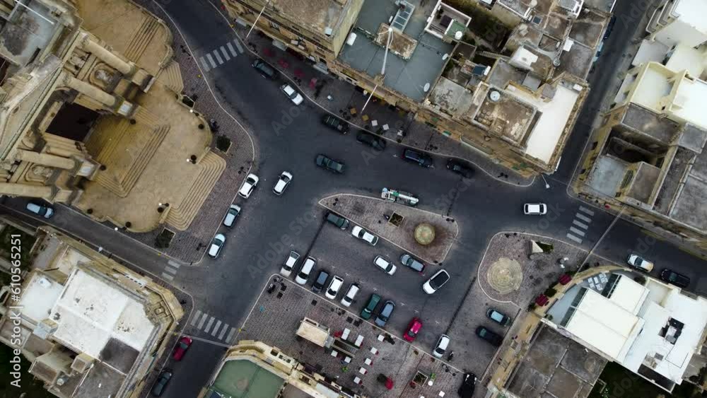 slow descend zoom-in to a roundabout intersection in Mediterranean city ...