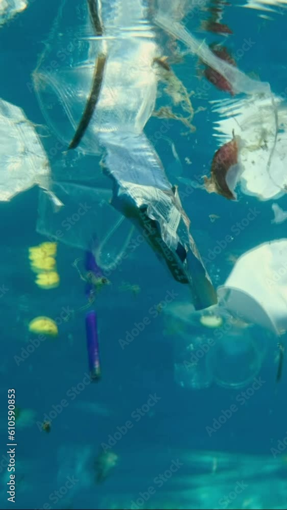VERTICAL VIDEO, Close-up of a lot of plastic debris slowly drifting ...