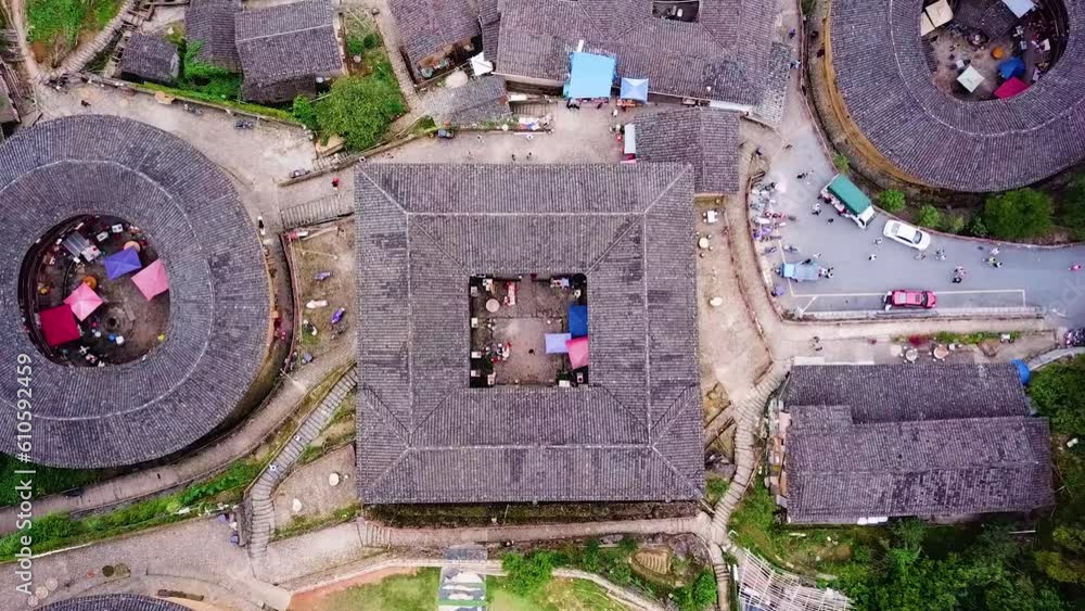 Drone shot zooms out of a square-shaped Unesco World Heritage Tulou ...