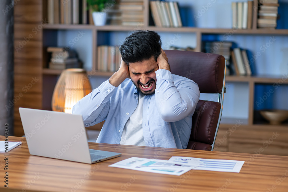 Unhappy male employee work online on laptop at home office frustrated ...