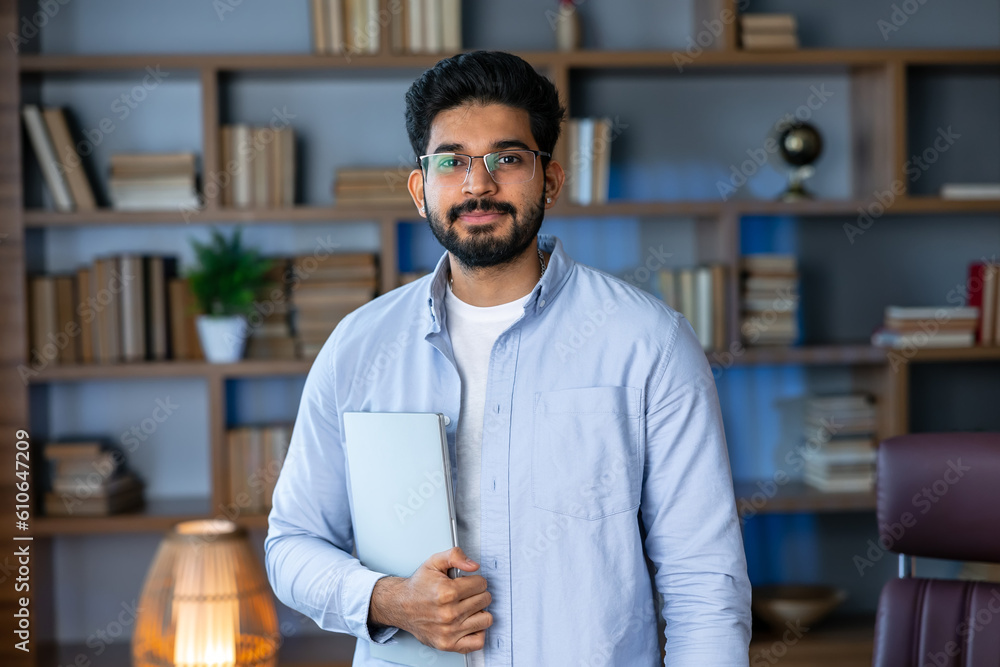 Smiling IT worker in blue shirt look at camera holding laptop at office ...