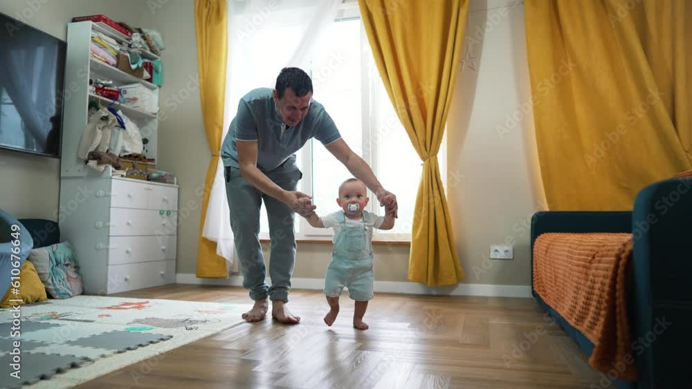 Baby first steps.Toddler at home takes funny first steps.Dad teaches ...