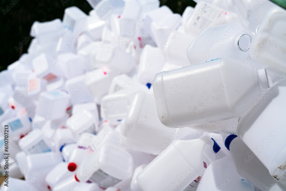 Used plastic saline bottles are stacked together waiting to be recycled ...