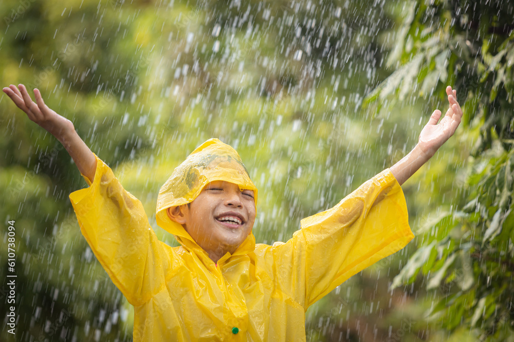 A boy wearing a yellow raincoat. Happy Asian little child having fun ...