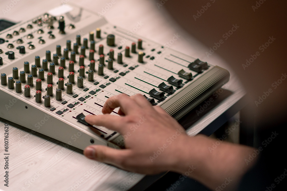 professional recording studio sound engineer with finger adjusts volume ...