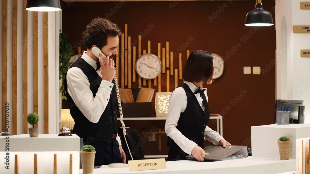 Teamworking professional hotel personnel checking tourists reservation ...